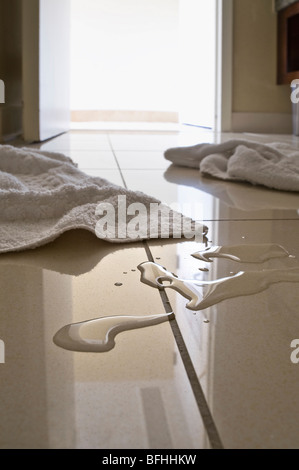 Puddles of water on the tile floor of a an airport public bathroom ...