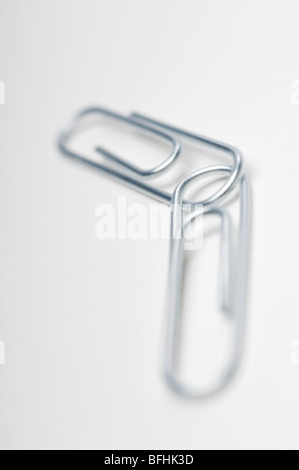 Two silver paper clips on white background Stock Photo - Alamy