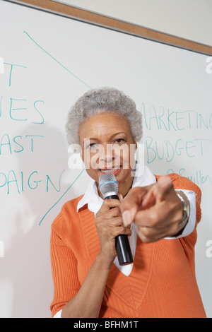 Female teacher using microphone indoors Stock Photo - Alamy