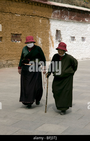 Two Tibetan women pilgrims in traditional dress, including their ...