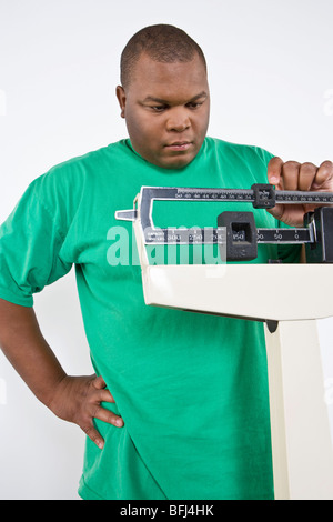Overweight man measuring his weight using scales on floor Stock Photo ...