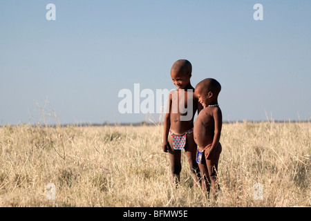 Botswana, Makgadikgadi. Bushmen children standing in the dry grasses of ...