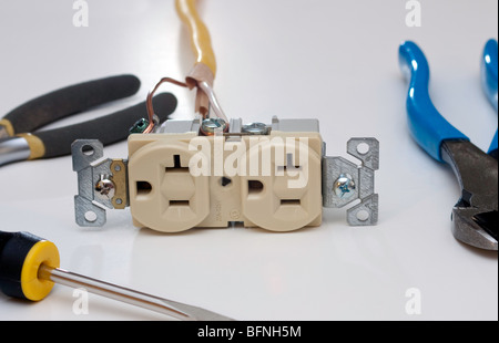 Photo of an electrical outlet with wire and the tools needed to install ...