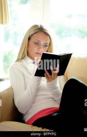 A blonde teen girl writing something into her diary Stock Photo - Alamy