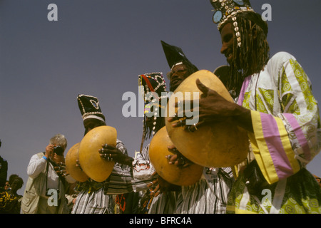 Fulani tribesmen playing a traditional form of drum made from dried ...