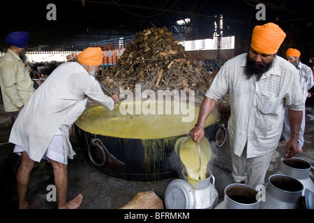 Sikh man stirring a big pan with dhal (curried lentils). The Golden ...