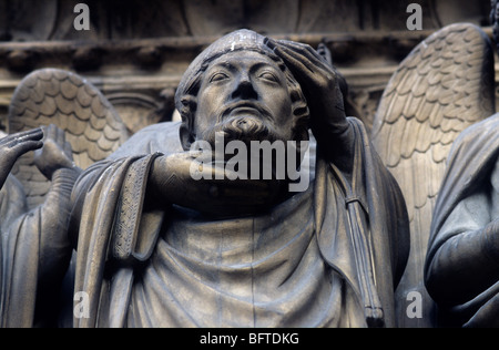 Statue of St Denis carrying his head flanked by angel on the left ...