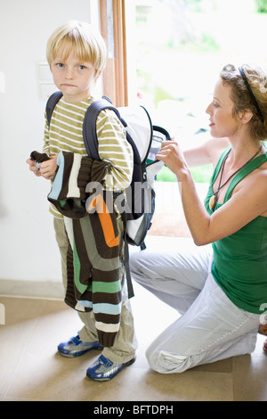 A Mother helping her son to get ready for school, buttoning up his shirt Stock Photo - Alamy