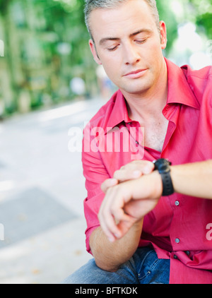 Man looking at his watch while waiting Stock Photo - Alamy
