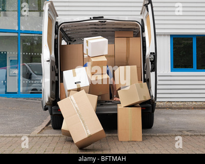 Man unloading boxes from the back of a delivery truck in early morning ...