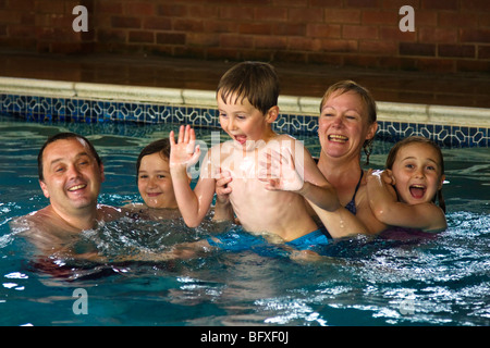 A family having fun in a swimming pool on a hot summer day ca. 1958 ...
