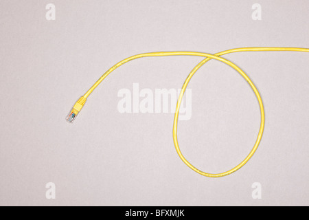 Internet cable and yellow ethernet connector in close up against a ...
