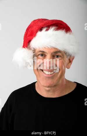 Smiling man in santa hat holding credit card near shopping cart with ...