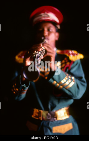 A one-armed man playing the trumpet with a focused expression against a ...