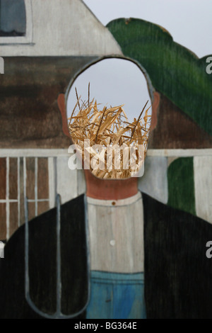Painting of American Gothic with cut out faces, in front of corn field ...