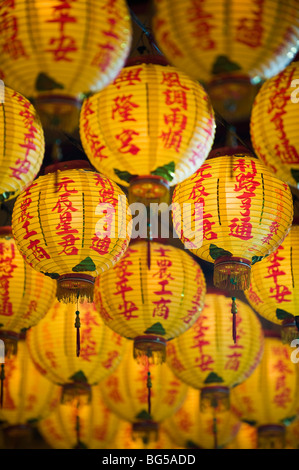Red lanterns with Chinese writing hanging from wooden roof in autumn w ...