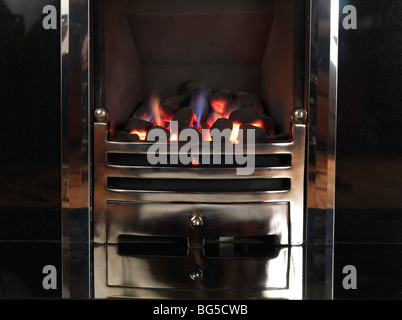 Cosy coal-effect gas fire within brass surround and showing a brass ...