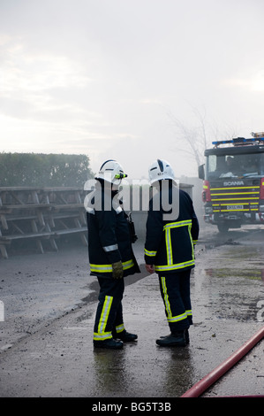 Two firemen with fire engine Stock Photo - Alamy