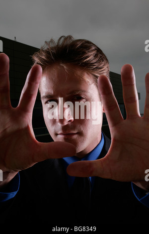 Studio shot of menacing businessman with hands on the desk, isolated ...