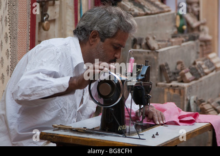 Local Indian man working as a tailor using an old fashioned sewing ...