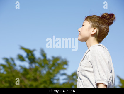 Young woman takes a deep breath outside, meditative pretty girl looking ...