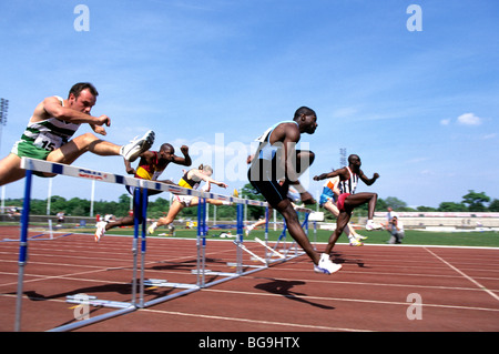 Group of male runners jumping over hurdles Stock Photo - Alamy
