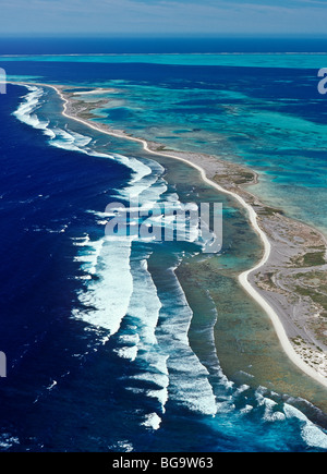 Island with a sand spit and coral reefs. Clear transparent sea near the ...