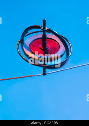 Toy gyroscope spinning and balancing on a small stand Stock Photo - Alamy