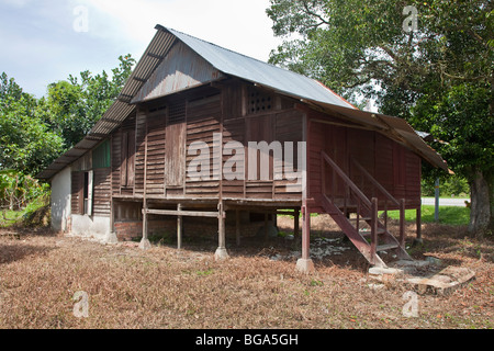 A traditional wooden Malay house on stilts with a tropically-suited ...
