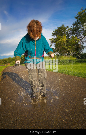 Woman splashing in muddy puddles Stock Photo: 96552805 - Alamy