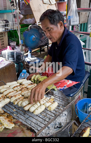 Man is cooking Thai sweet street food stir fried ice cream rolls from ...