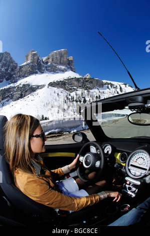 Woman driving Mini Cooper at the Gardena Pass, Alpine pass, South Tyrol ...