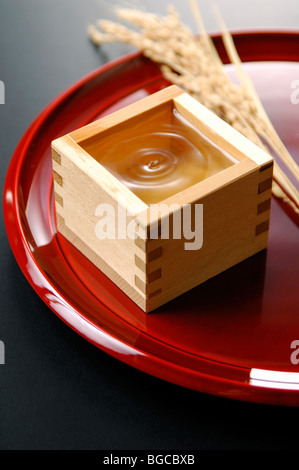 Sake in small wooden box Stock Photo - Alamy