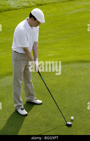 view of a golfer teeing off from a golf tee on a bright sunny day on a ...