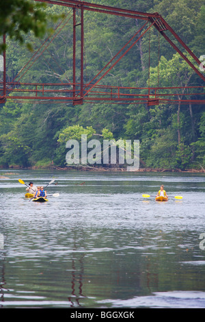 A man paddling a kayak under a bridge along the Landwehr Canal in the ...