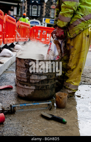 Concrete & cement being prepared by spade & shovel and hand powered ...