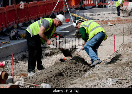 Concrete & cement being prepared by spade & shovel and hand powered ...