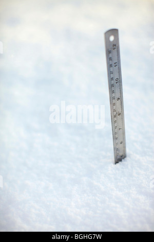 Ruler in snow measuring snowfall depth and ice accumulation from winter ...