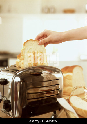 Taking toast out of a toaster Stock Photo - Alamy