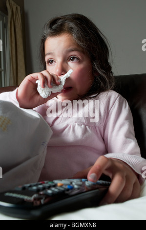 Sick girl with cold sitting on sofa Stock Photo - Alamy