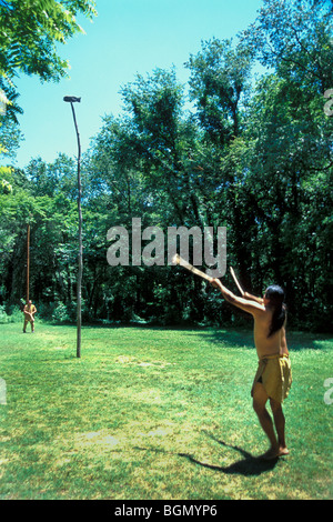Traditionally dressed Cherokee man demonstrates how a stickball game ...
