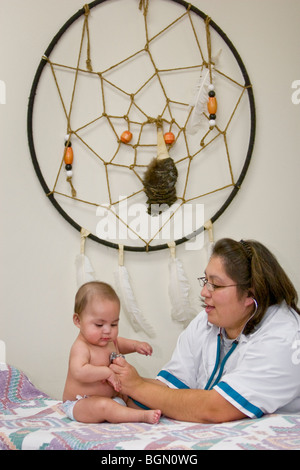 Native American nurse examines an infant at a medical center Stock ...