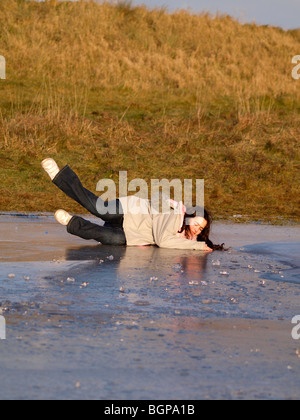 Young girl slip and fall on the snow Stock Photo - Alamy
