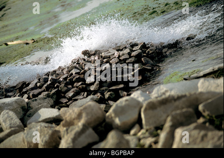 Wave breaking over rocks with water splashing with blue sky Stock Photo ...