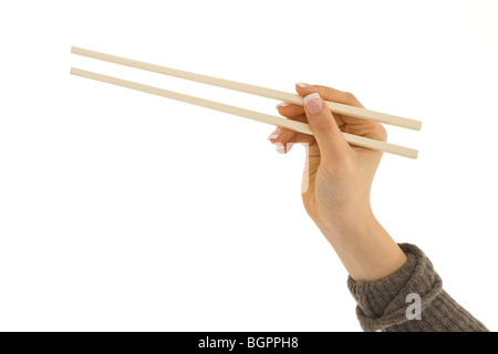 Asian hand holding a pair of chop sticks in front of a white background ...