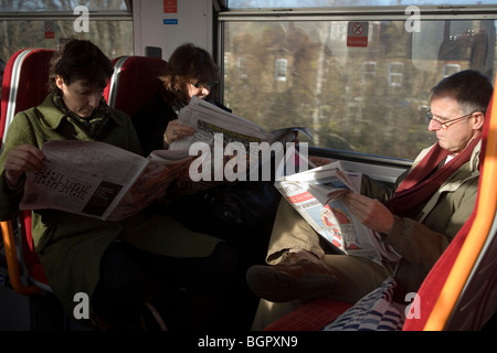 People reading newspapers on London Underground, UK Stock Photo - Alamy