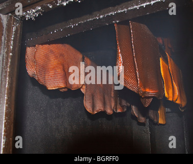 Smoking rubber sheets in a smokehouse. Sheets of latex are first dried ...