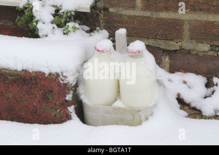 Milk bottles on doorstep in snow Stock Photo - Alamy