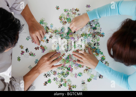 Men holding and putting a piece of jigsaw puzzle together. Two hands ...