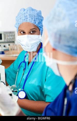 Asian female doctor talking on phone in hospital clinic office for ...